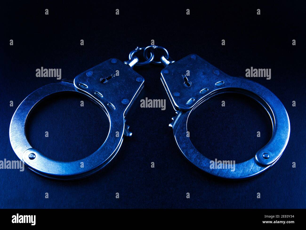 Toned Photo of Handcuffs on the Dark Background closeup Stock Photo - Alamy