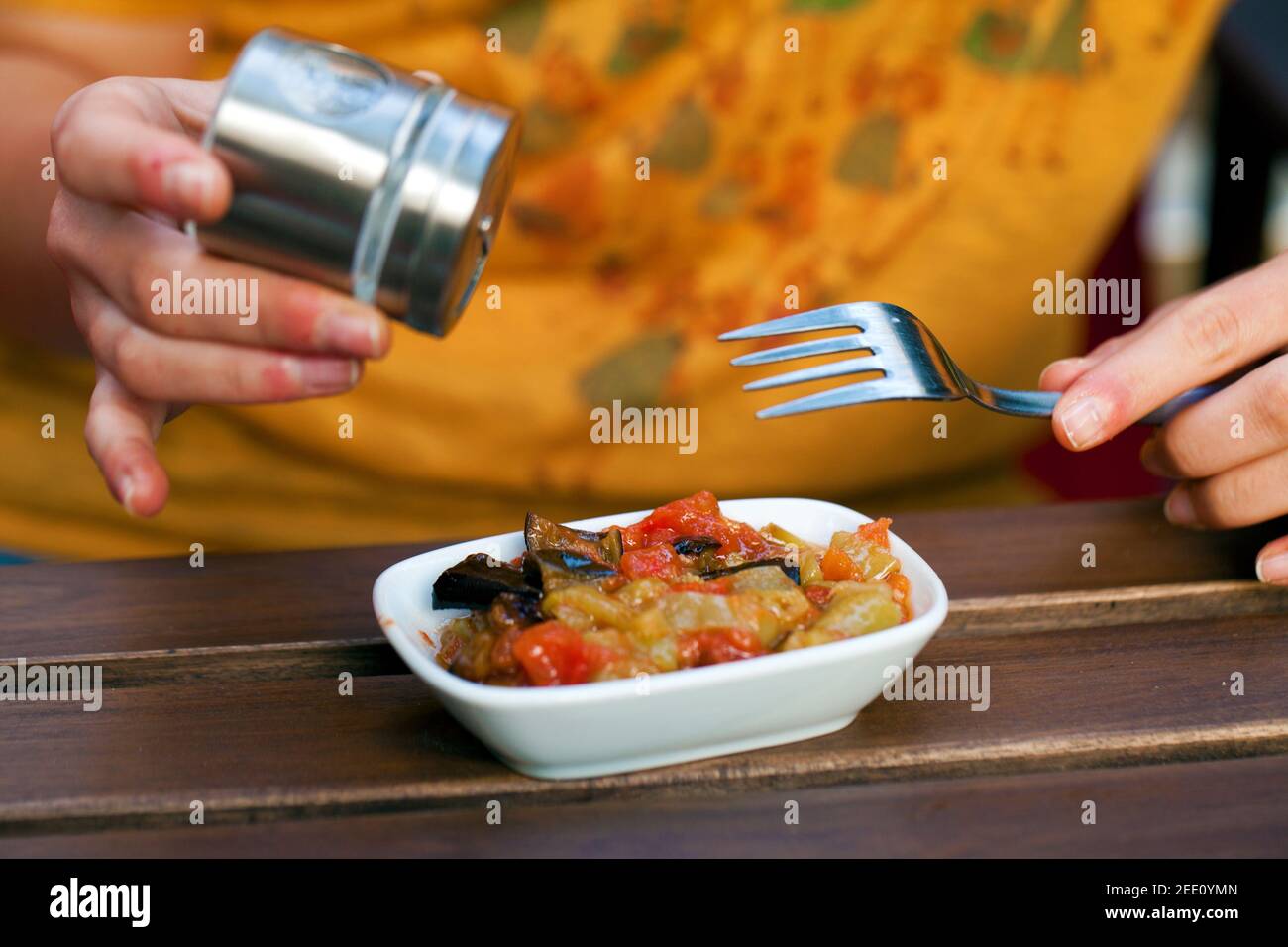 Girl is adding Salt to Delicious Meal Photo Stock Photo - Alamy