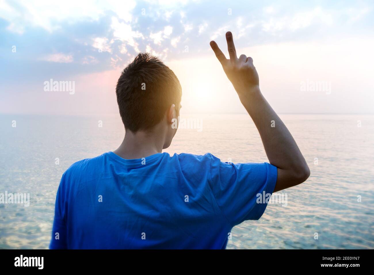 Happy Man with Victory Gesture on the Sea Background Stock Photo - Alamy