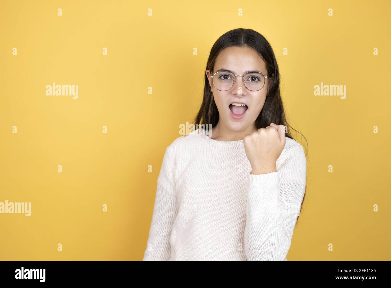 Beautiful child girl wearing casual clothes angry and mad raising fist ...
