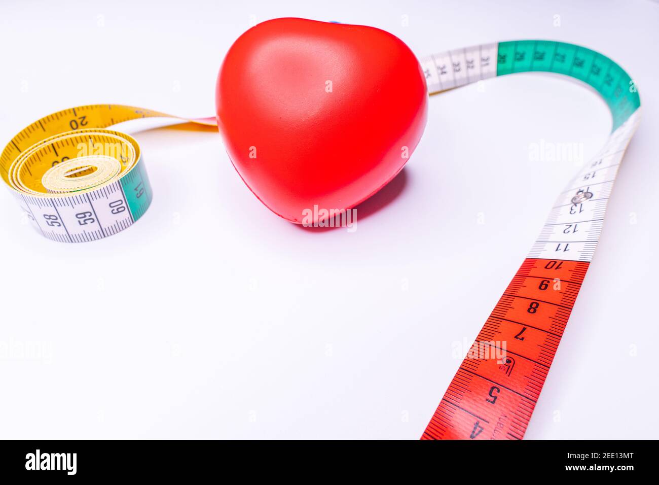 Top view red heart shape and white measurement tape on white background ...