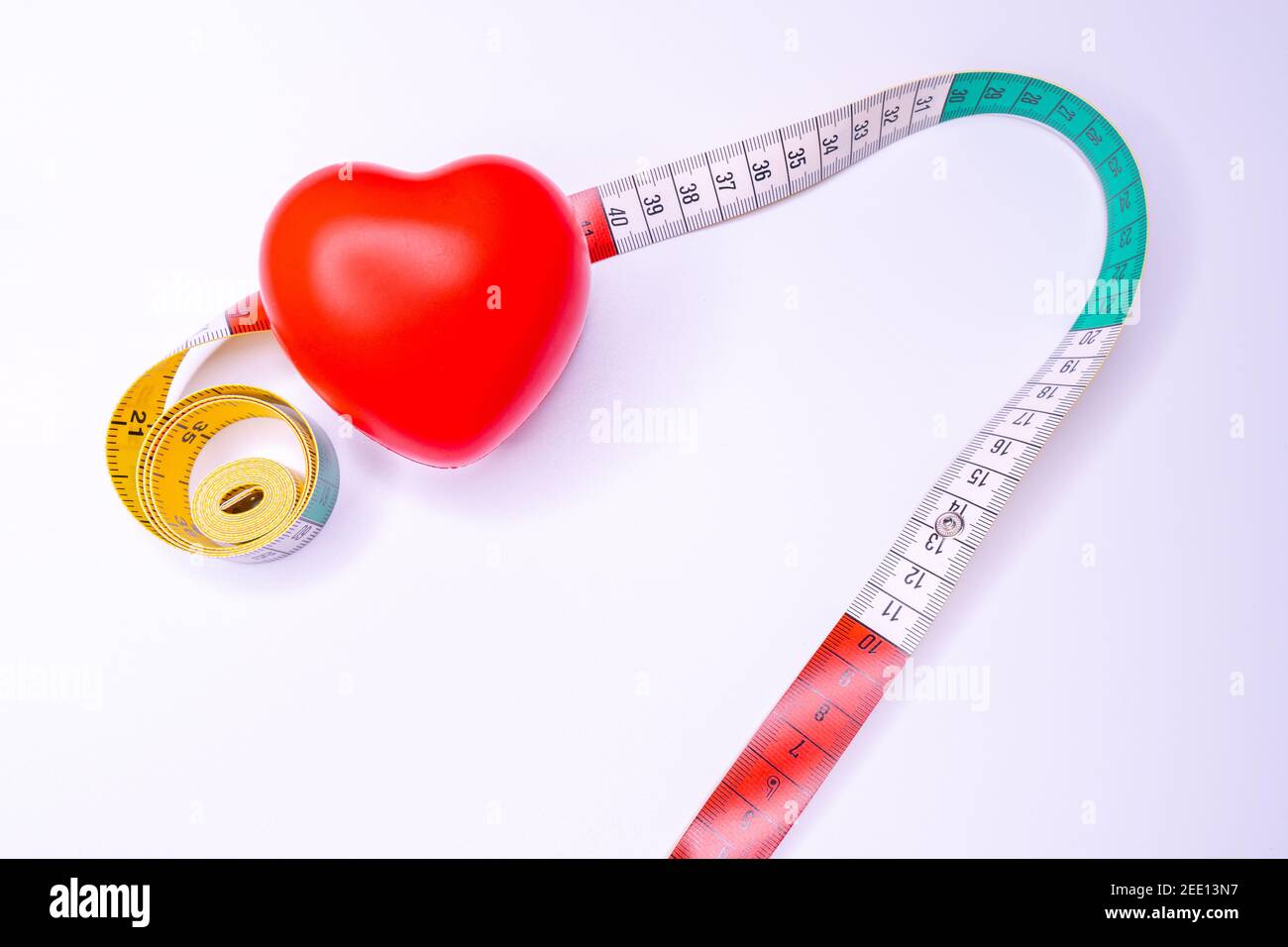 Top view red heart shape and white measurement tape on white background ...