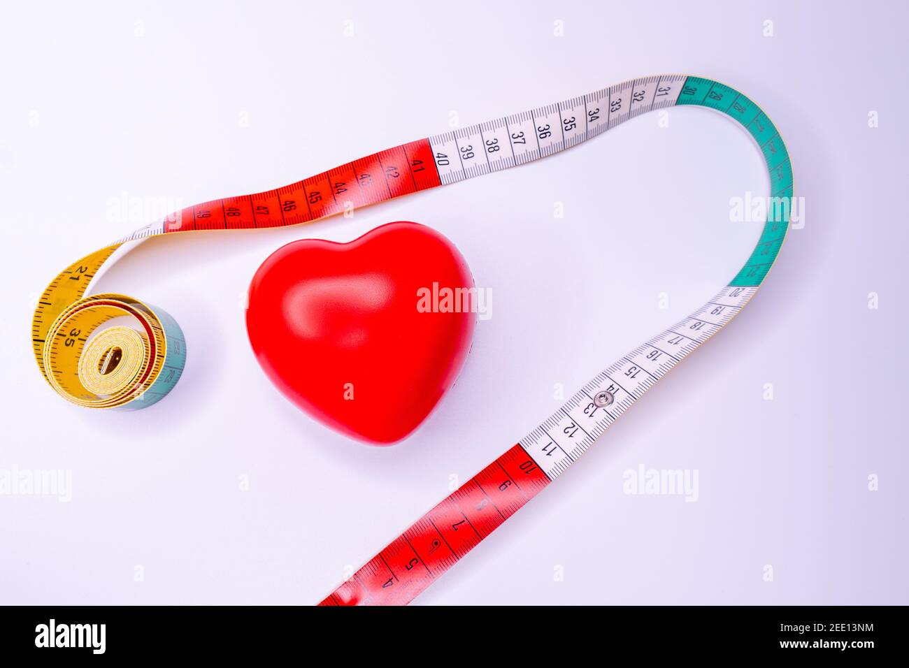 Top view red heart shape and white measurement tape on white background ...
