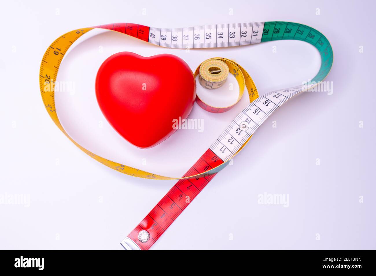 Top view red heart shape and white measurement tape on white background ...