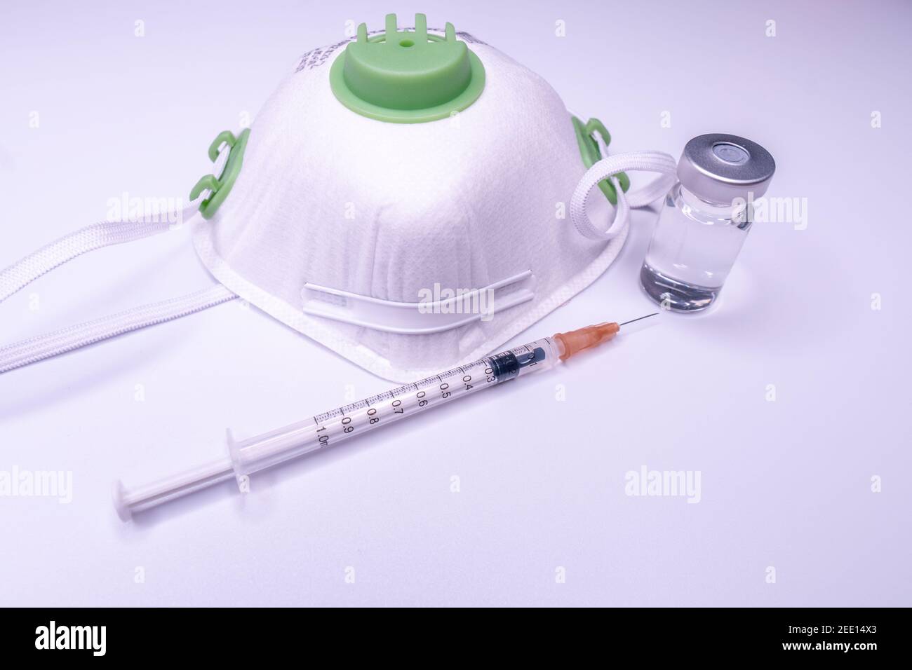 Medical bottle, vials, syringes and face mask on blue background with ...