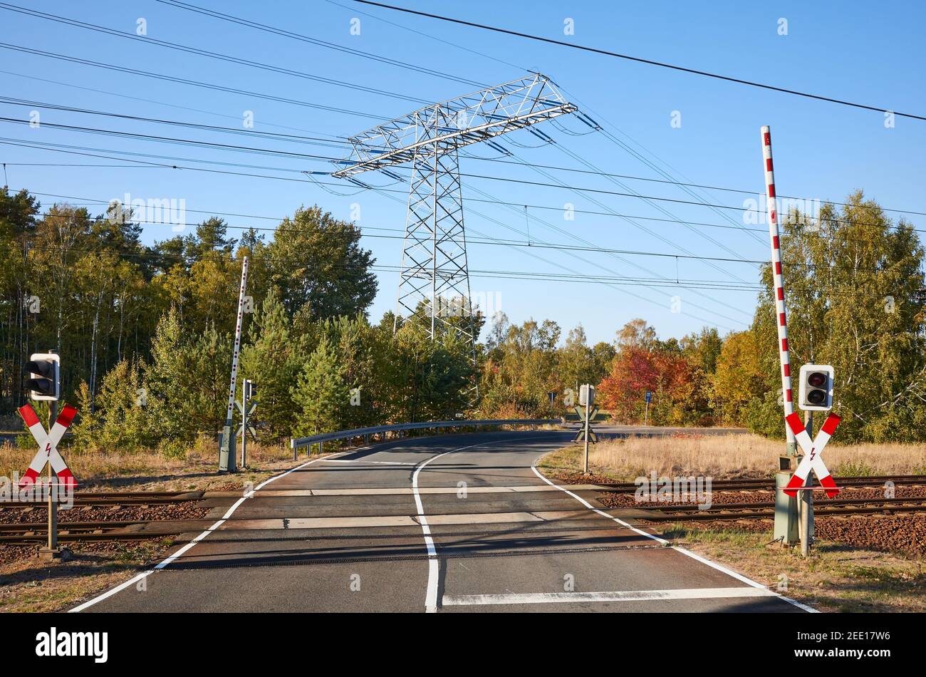 Rail crossing with high voltage power transmission line in background ...