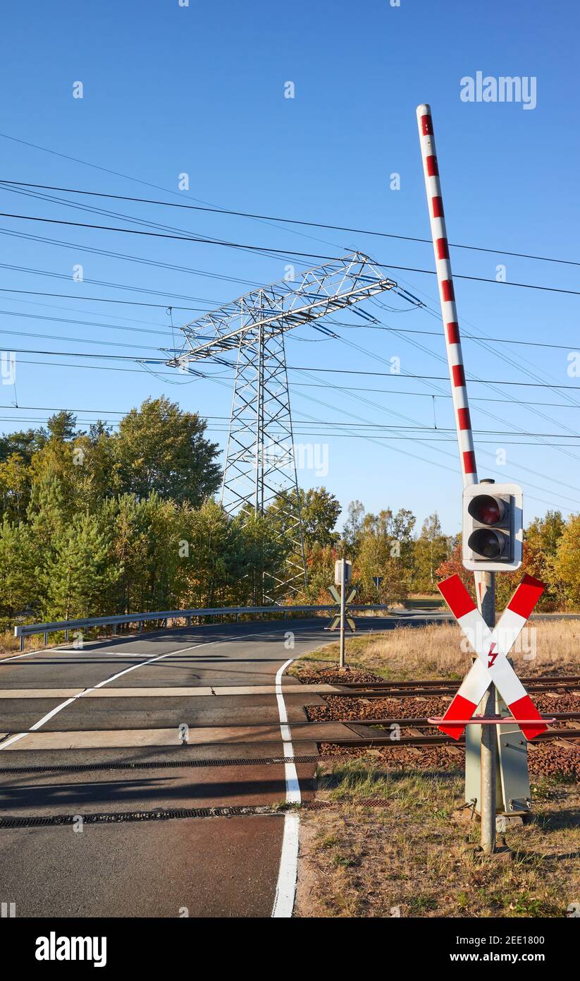 Rail crossing with high voltage power transmission line in background ...