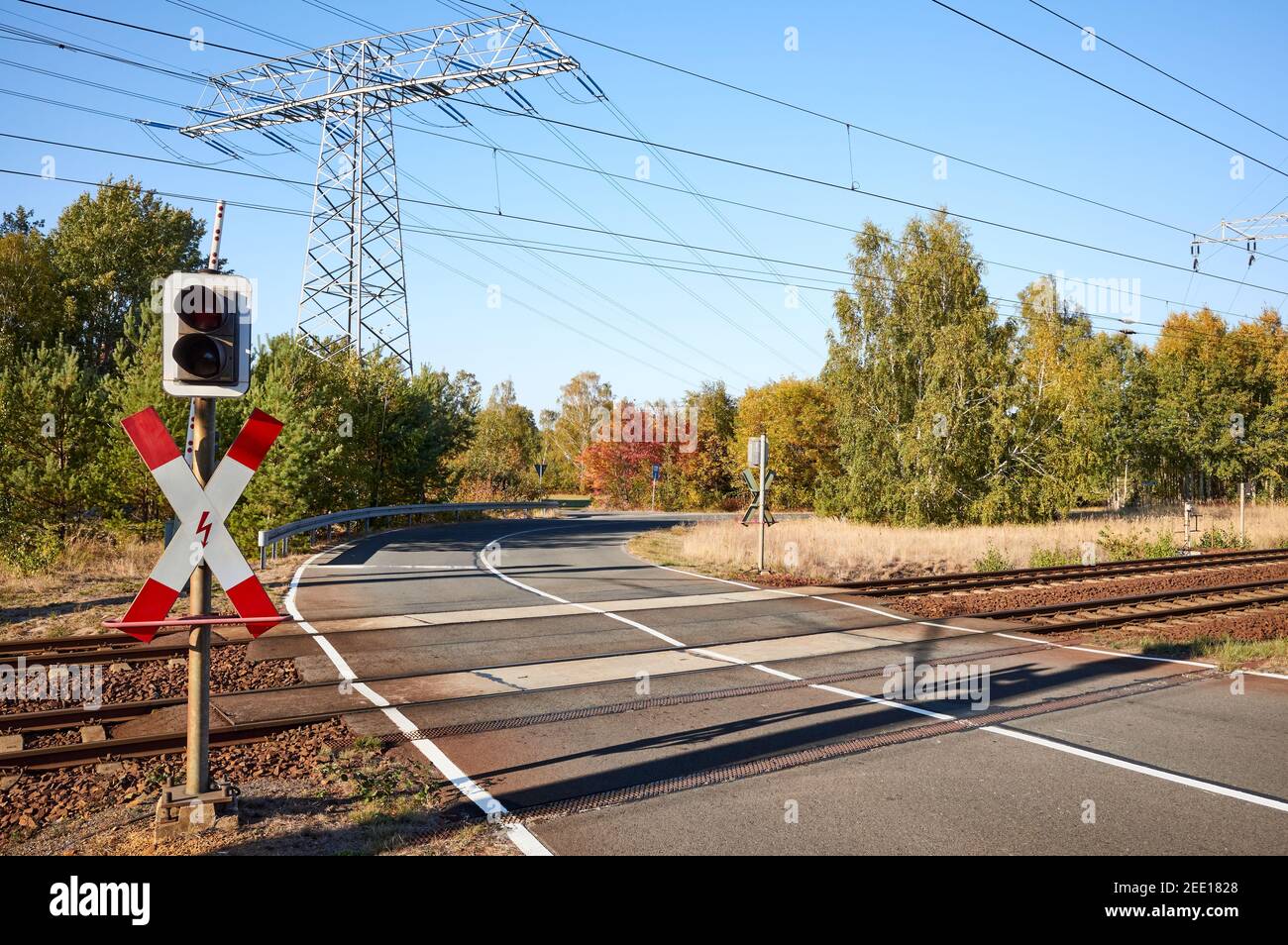 Rail crossing with high voltage power transmission line in background ...