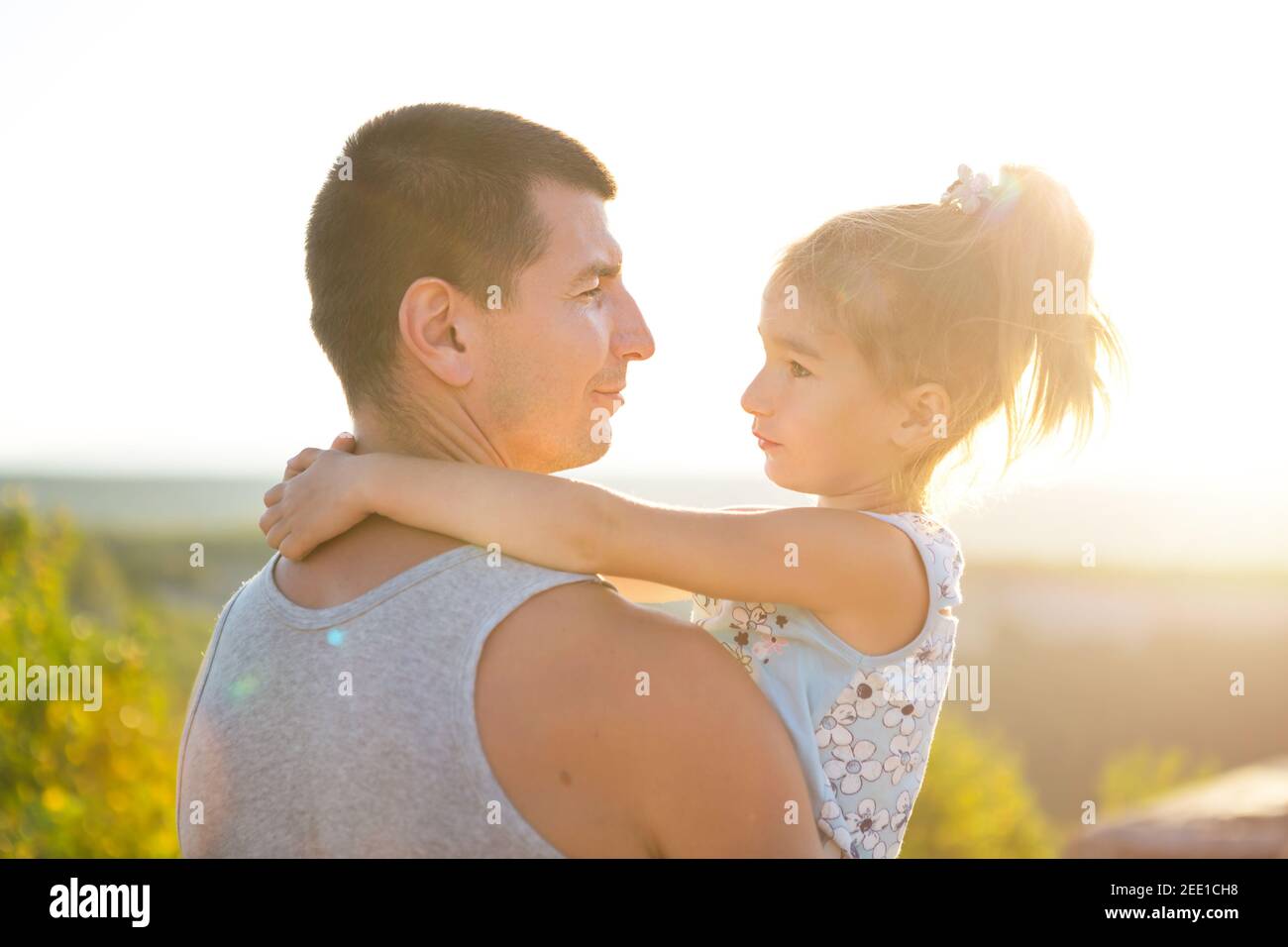 The father and daughter hug tightly, the girl holds the father by the ...