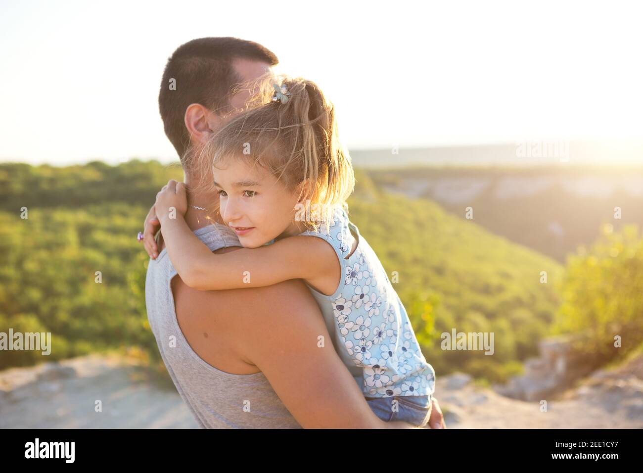 The father and daughter hug tightly, the girl holds the father by the ...