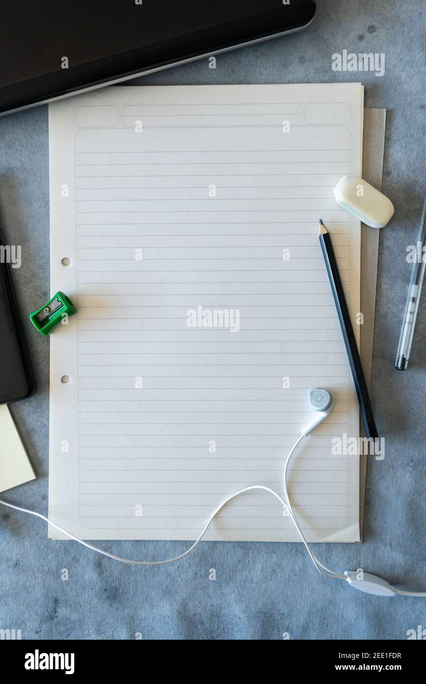 Top view of a blank sheet with earphones, pencil, pen,eraser and ...