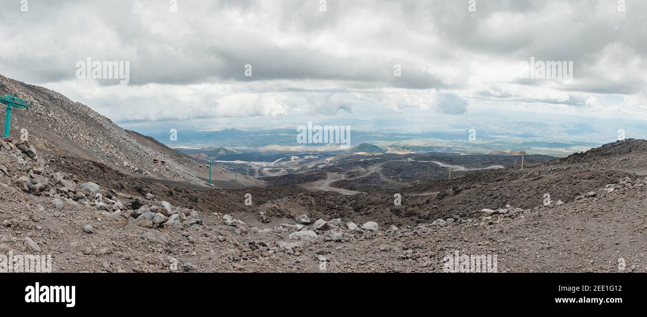 Top of crater Mount Etna volcano, frozen cold lava smokes, thick clouds ...