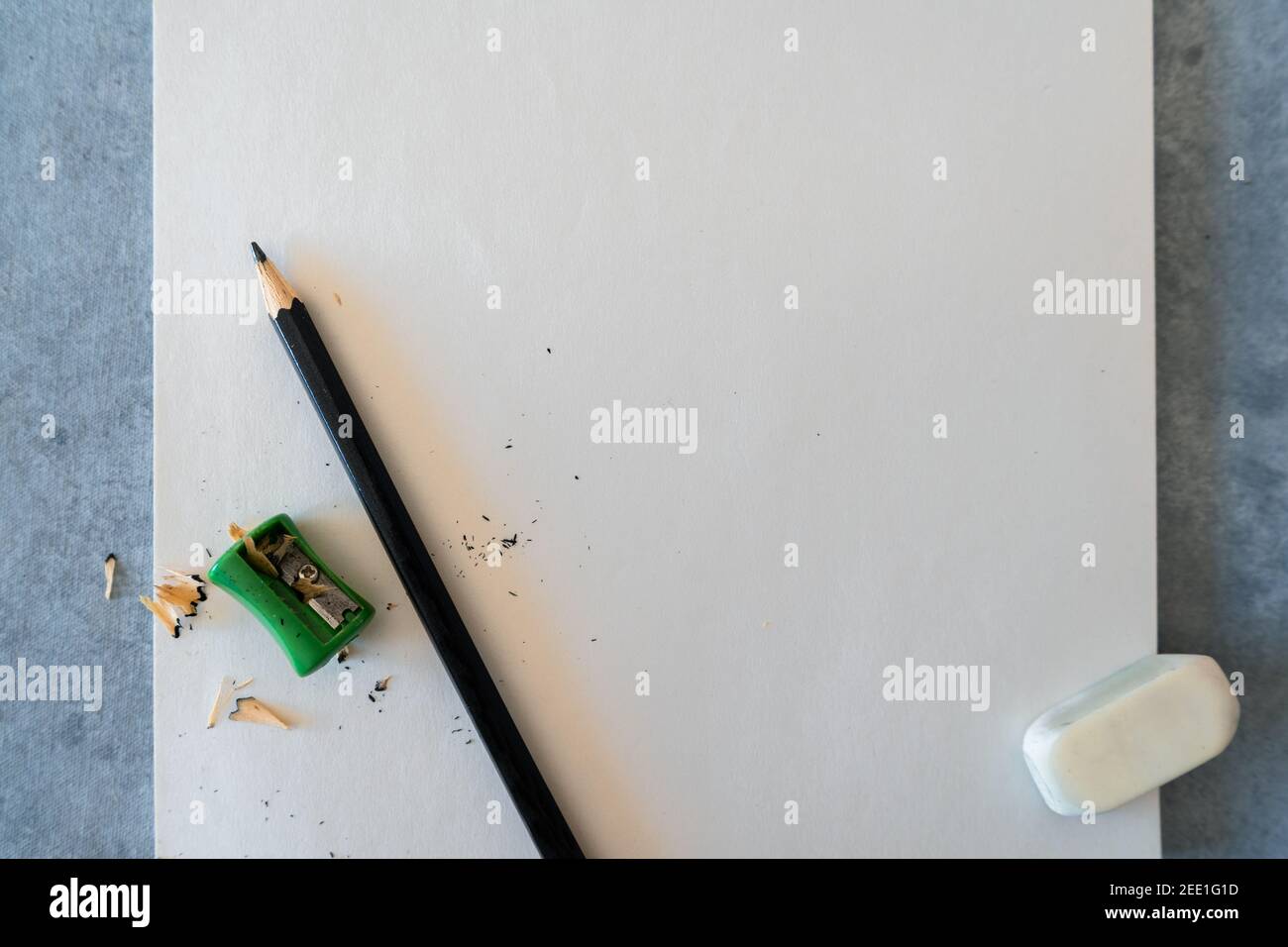 Top view of blank drawing sheet with a sharp pencil, sharpener and ...
