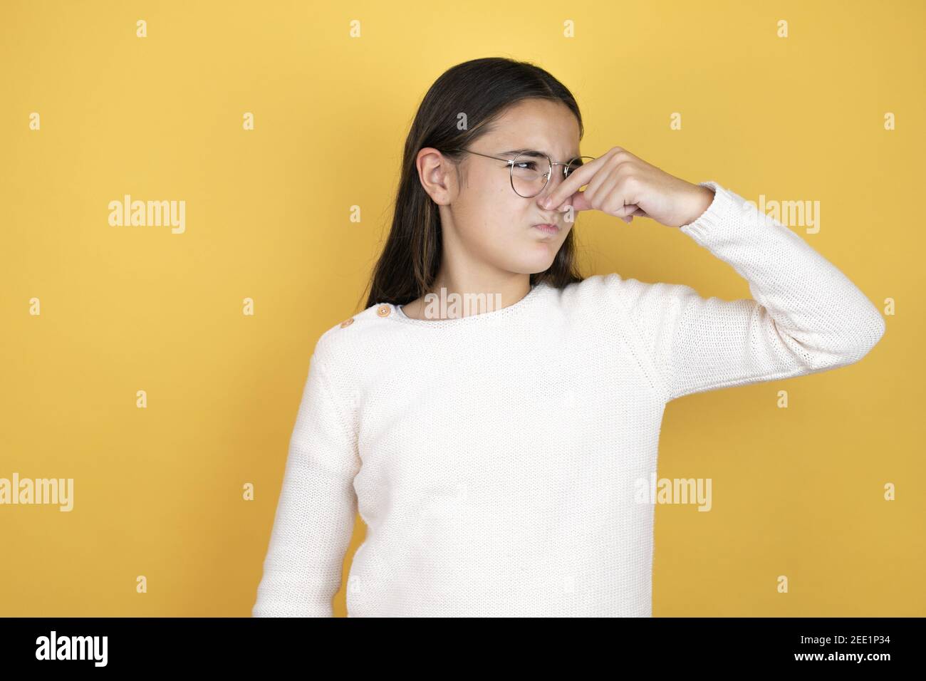 Beautiful child girl wearing casual clothes smelling something stinky ...