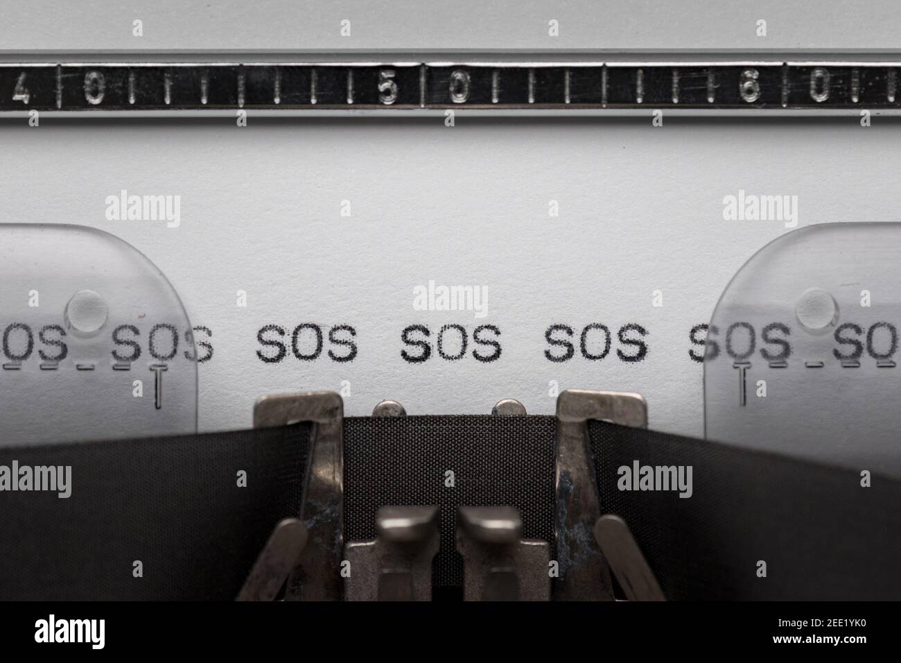 Typing text SOS on vintage manual typewriter. Close up of writes word ...