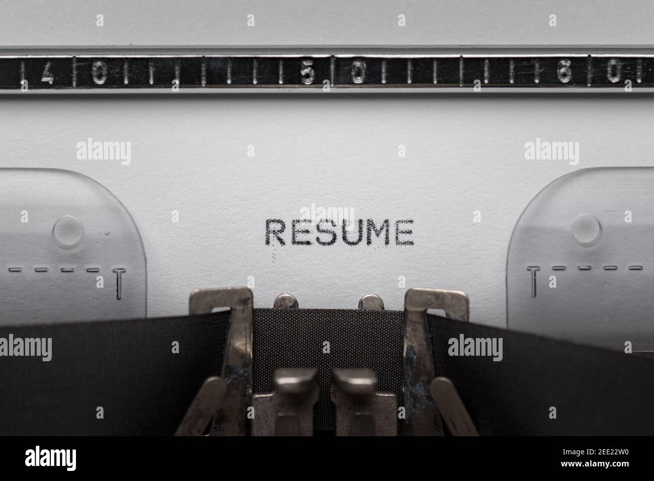 Typing text RESUME on vintage manual typewriter. Close up of writes ...