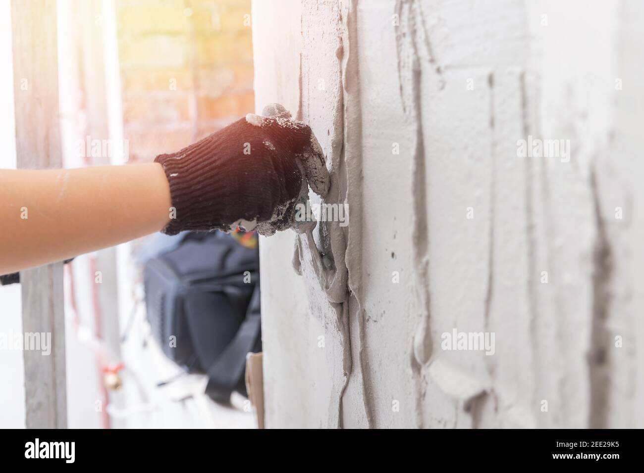 Initial application of putty and plaster on concrete wall to level ...