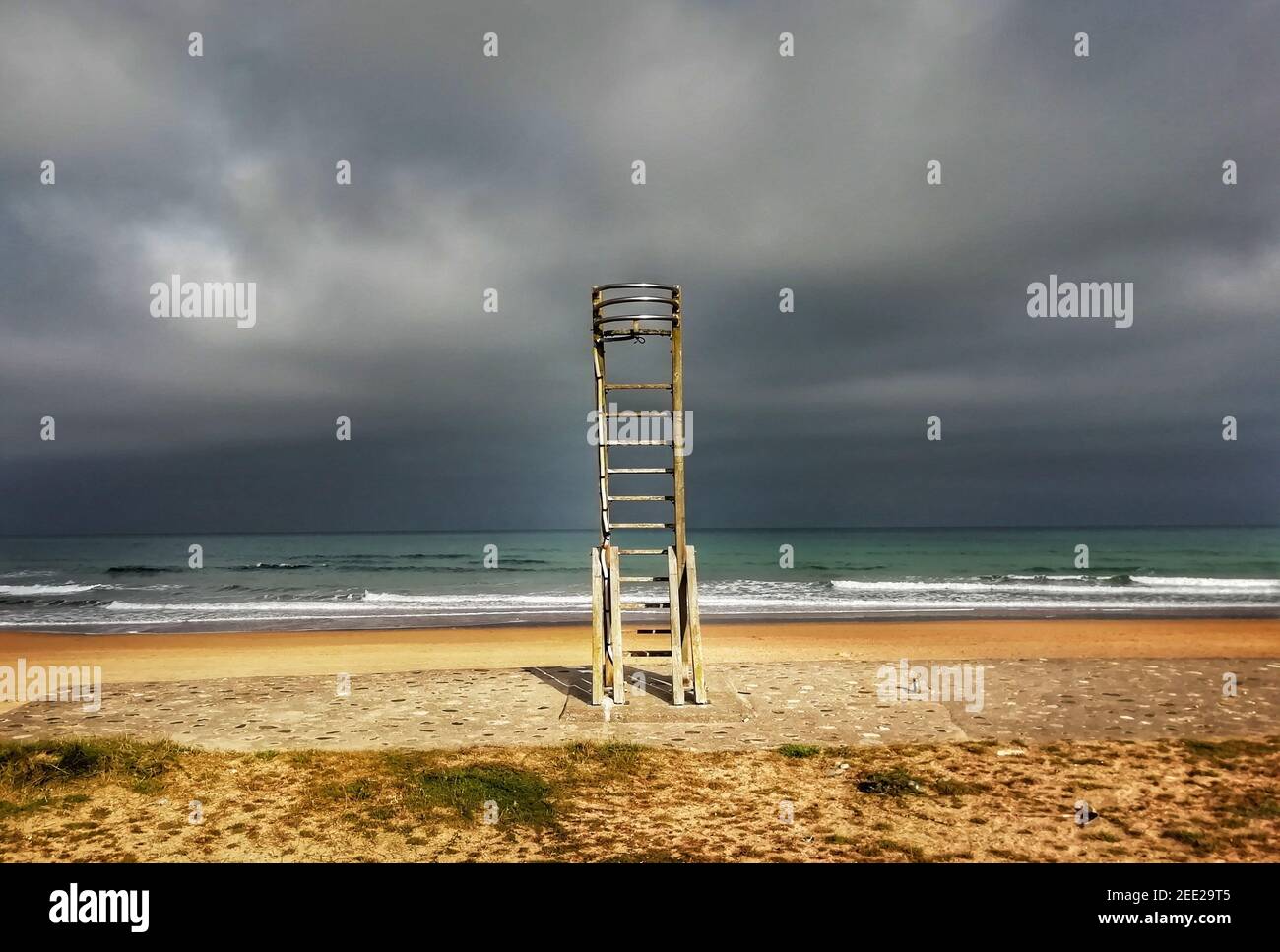 Observation tower on the beach on the background of the cloudy dark sky ...