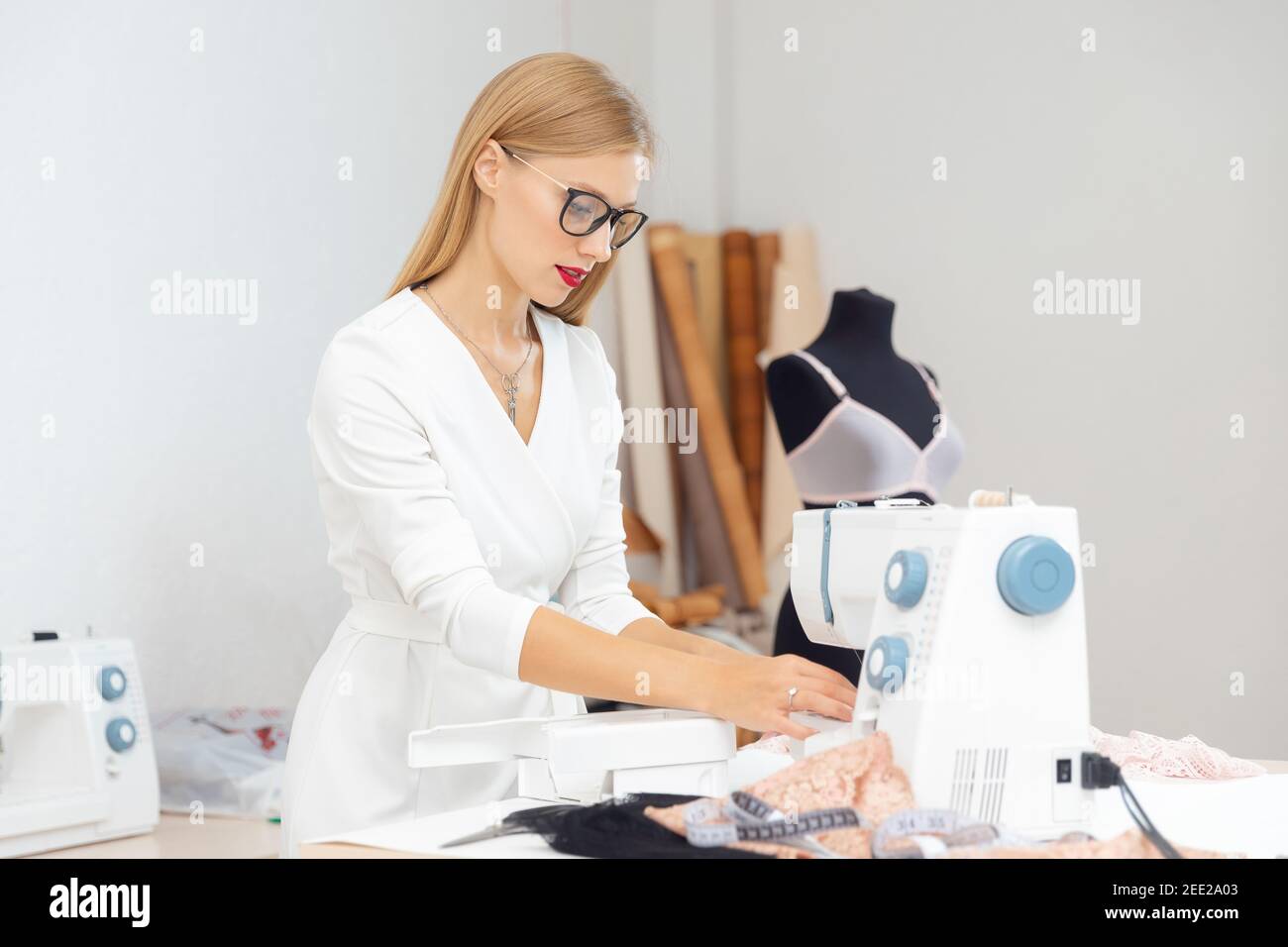 Caucasian young woman tailor works on sewing machine Stock Photo - Alamy
