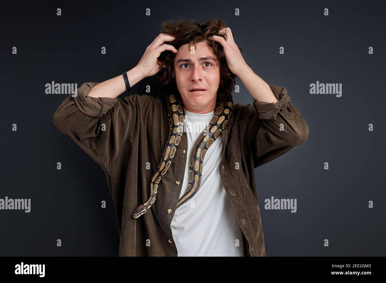 man in confusion does not know what to do with snake on him, grabbed ...