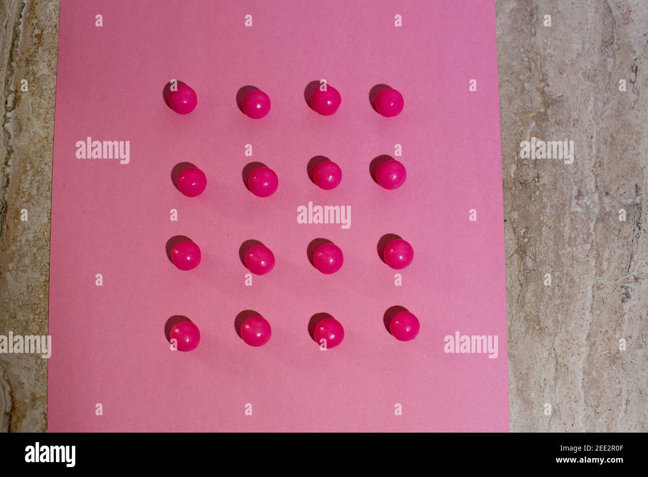 Candy is arranged on colorful paper creating repetitive patterns ...