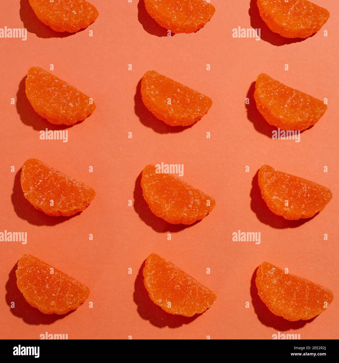 Candy is arranged on colorful paper creating repetitive patterns ...