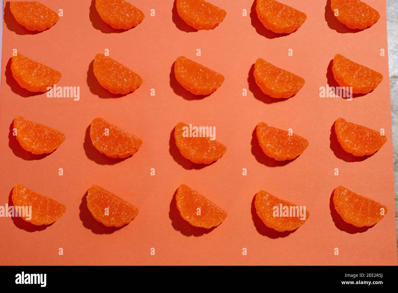 Candy is arranged on colorful paper creating repetitive patterns ...