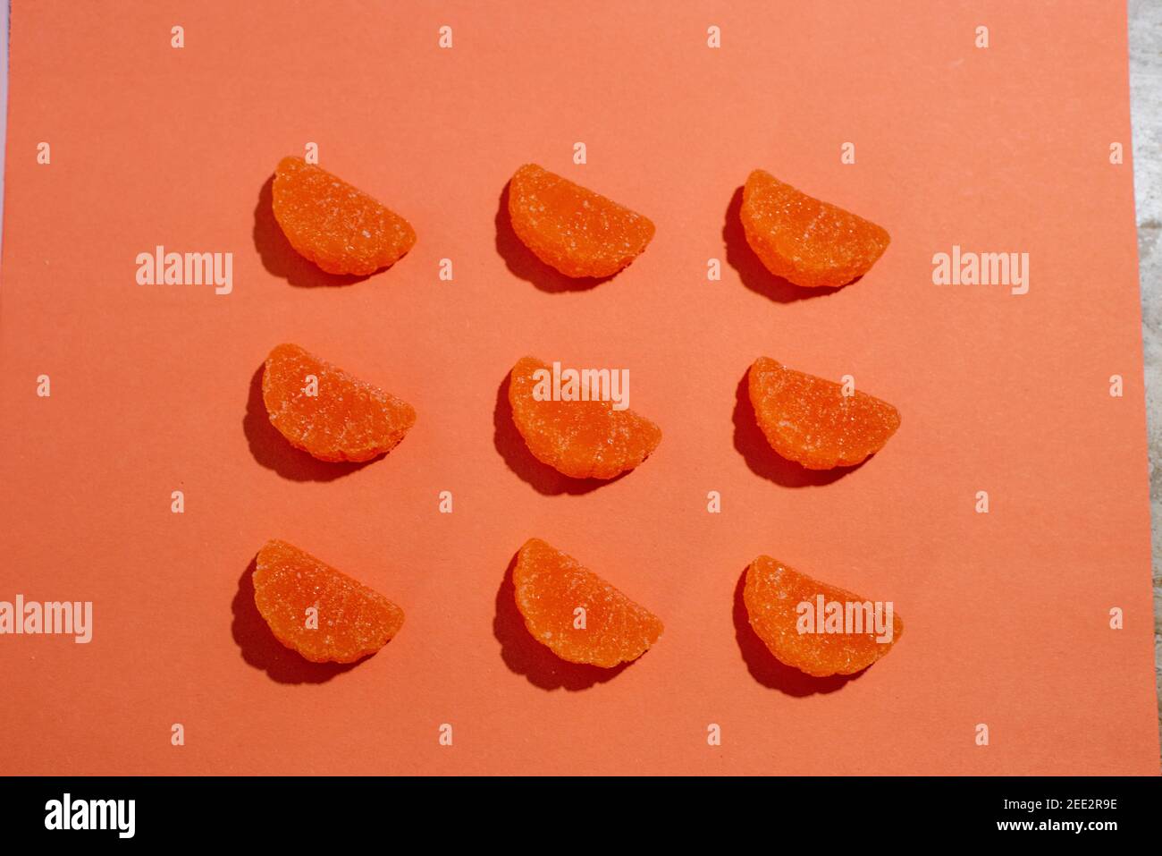 Candy is arranged on colorful paper creating repetitive patterns ...