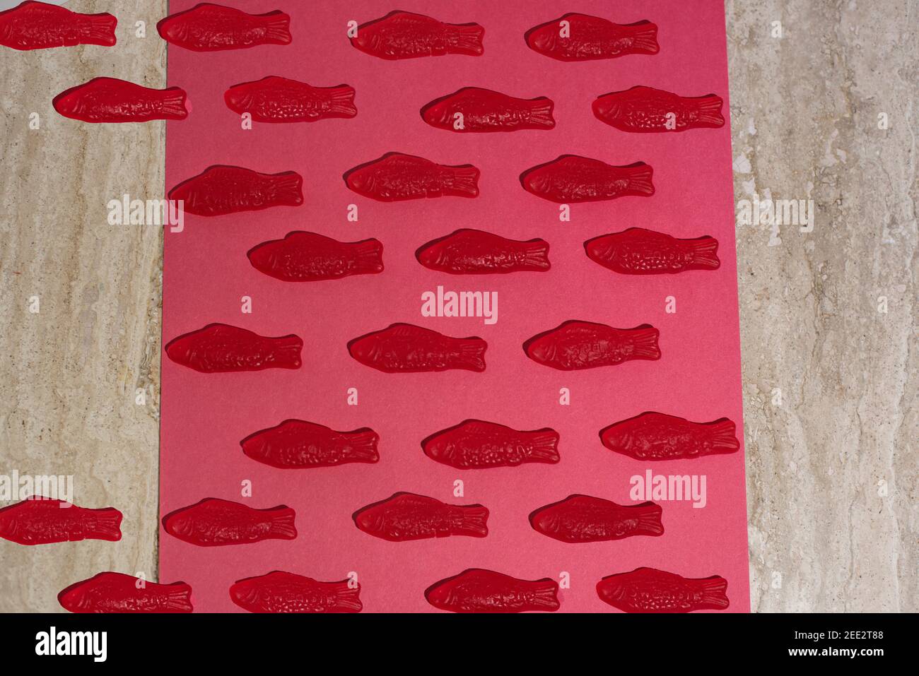 Candy is arranged on colorful paper creating repetitive patterns ...