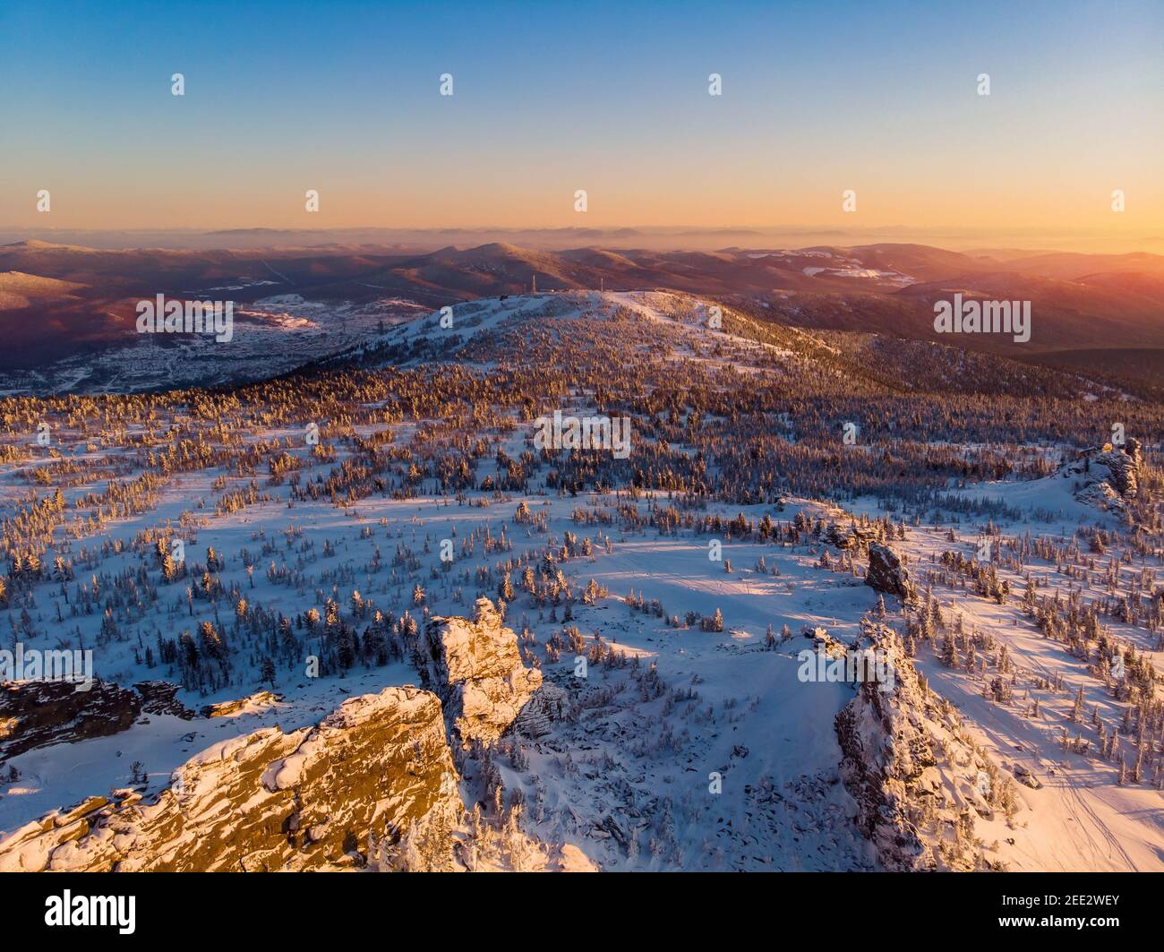 Colorful winter sunset in Sheregesh ski resort mountains covered trees ...