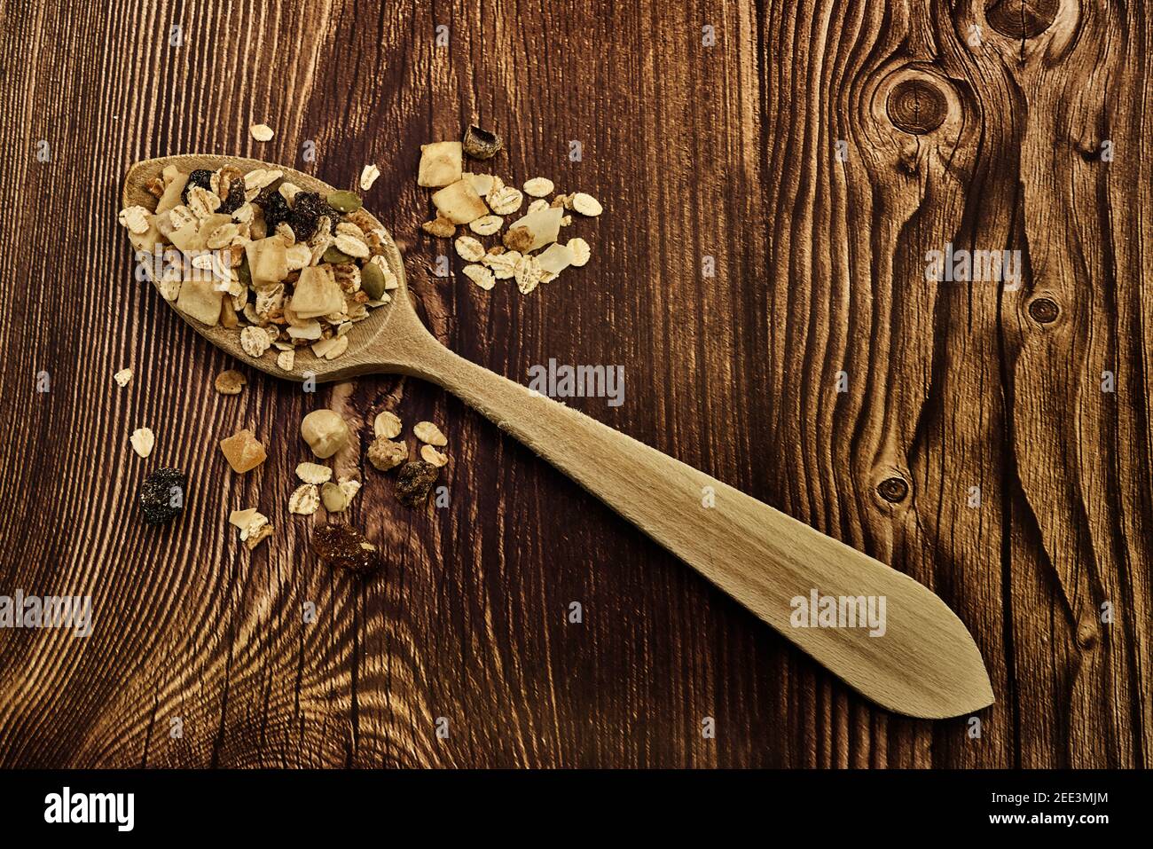 Wooden spoon with a heap of nuts and muesli on a wooden table Stock ...