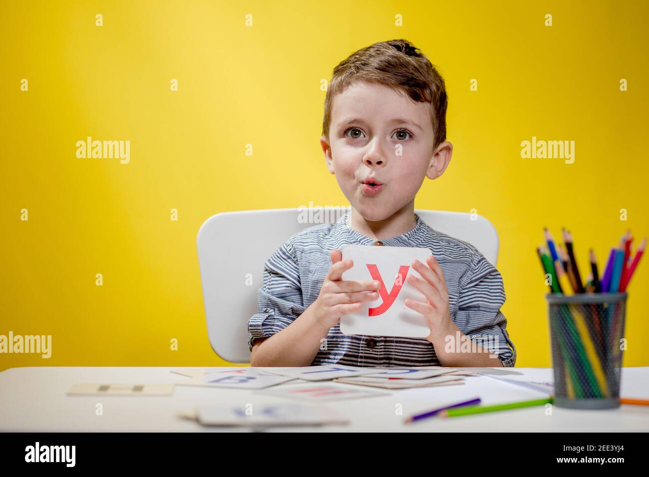 Happy smiling little preschool boy shows letters at home making ...