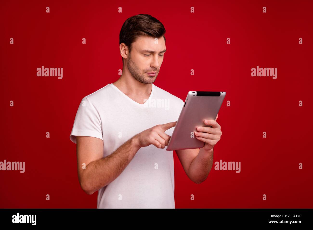 Portrait of half turned handsome young person using tablet look screen ...