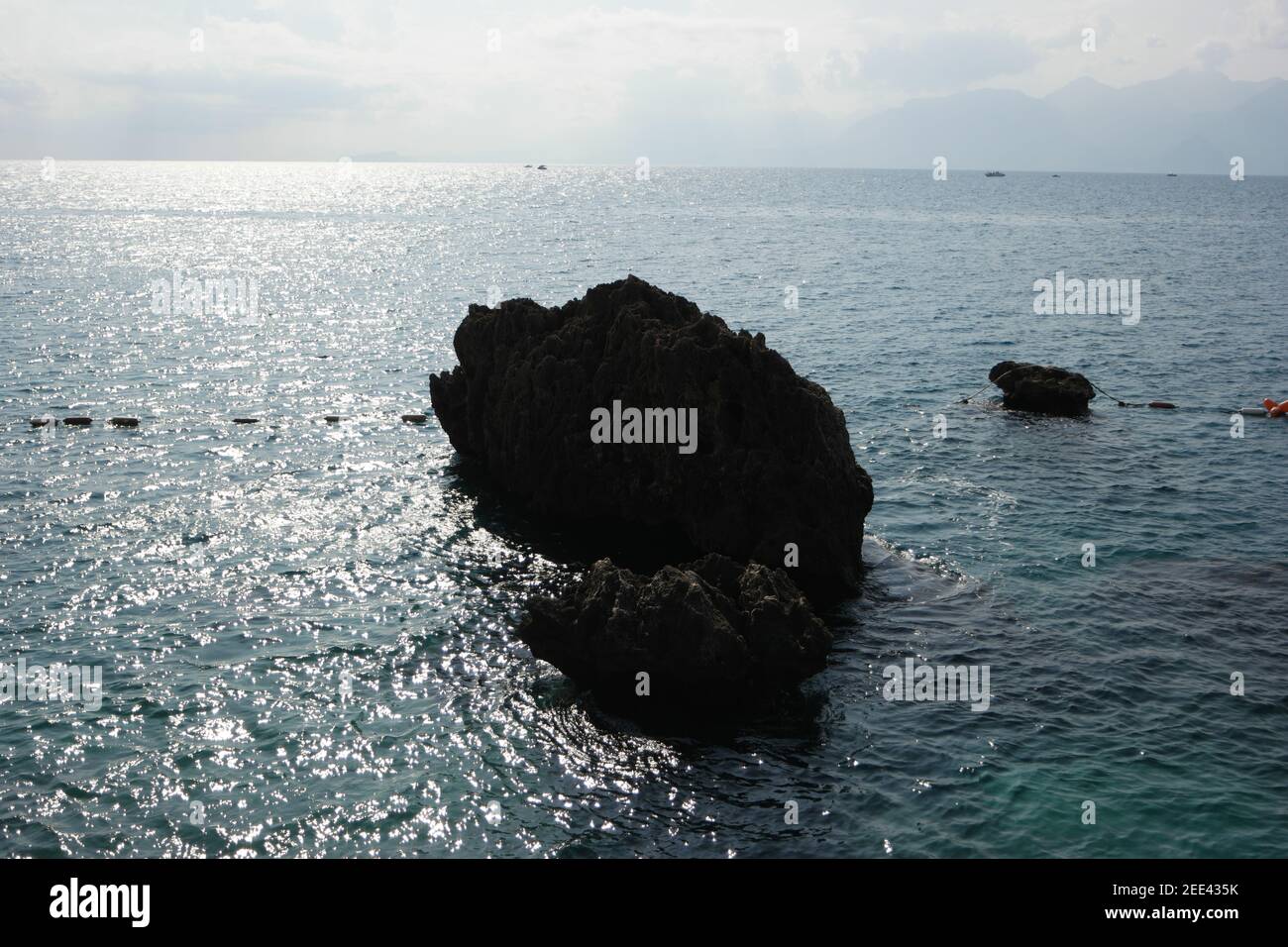 Rock in turquoise sea water Stock Photo - Alamy