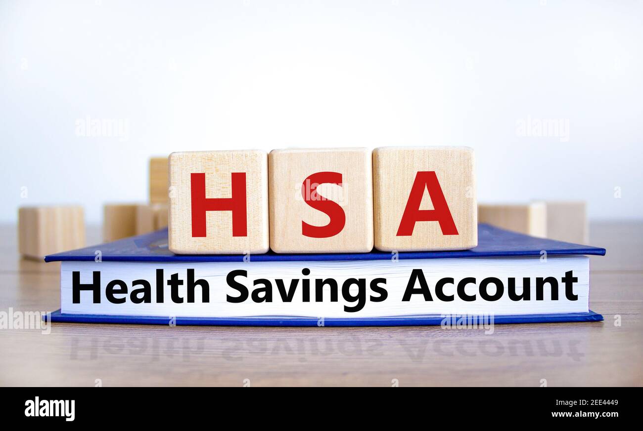 HSA, health savings account symbol. Wooden cubes on book with words ...