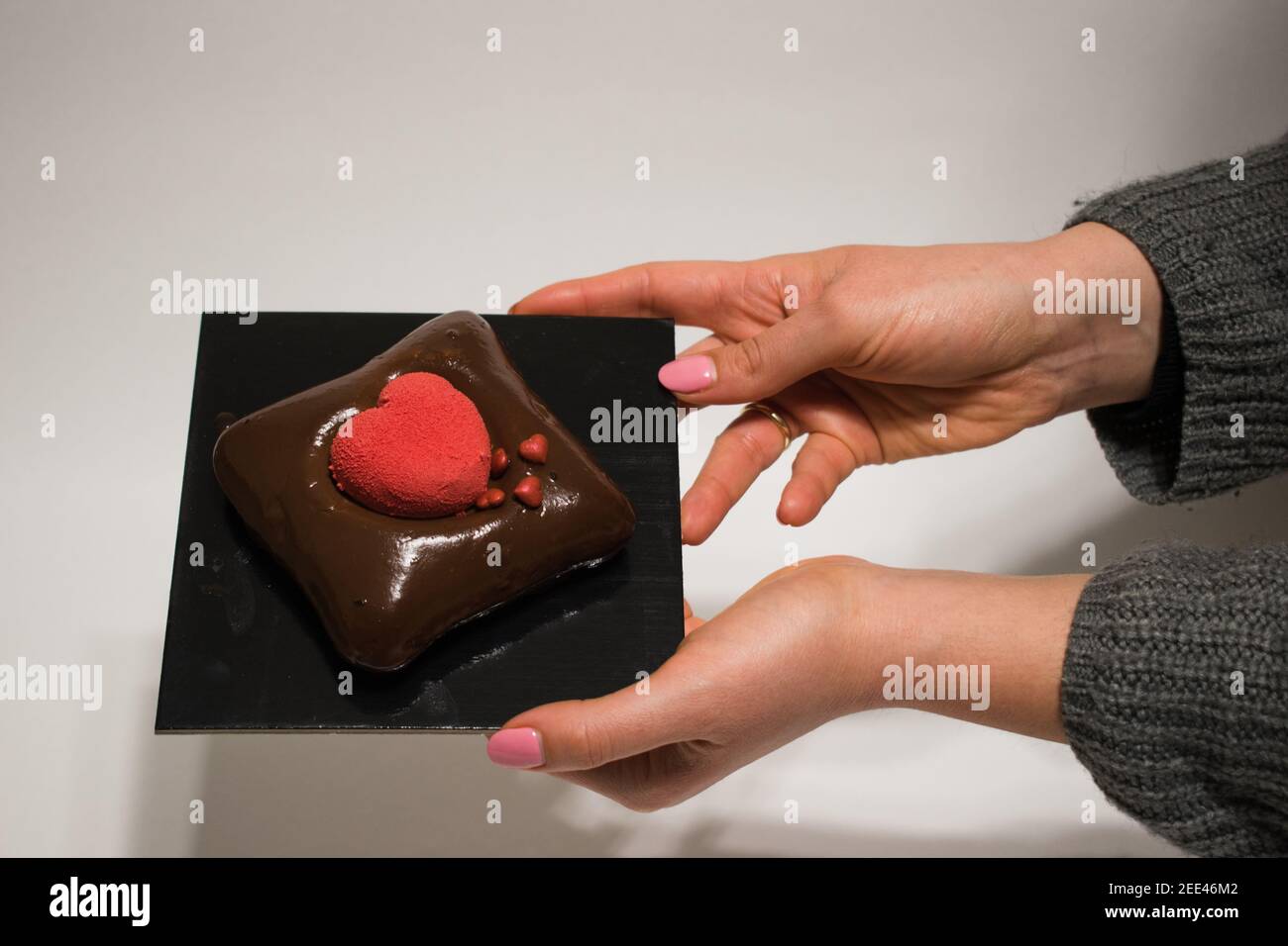 Woman holding black take away cardboard filled with sweet chocolate ...