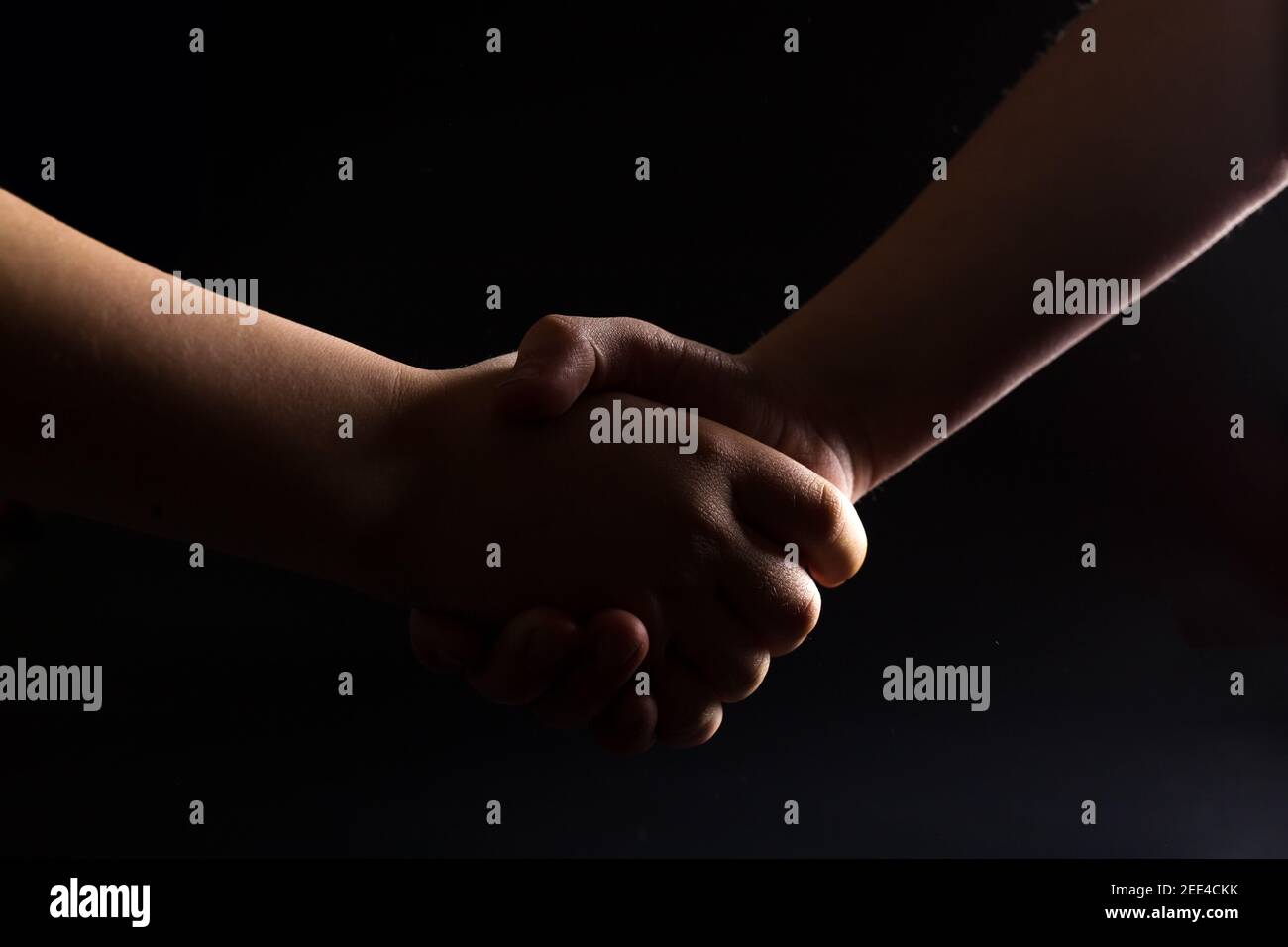 Handshake of children's hands, Children hands close up on black ...