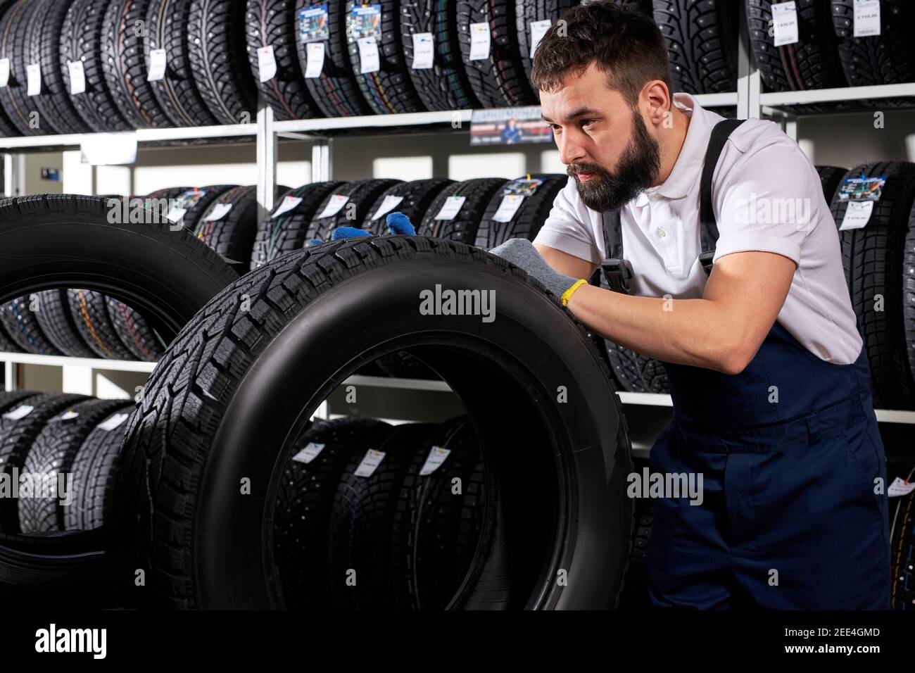 auto mechanic salesman examining tire surface in his shop against the ...