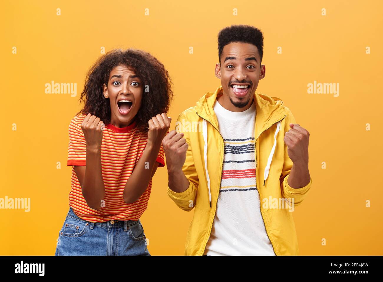 Two friends cheering and supporting mate on competition yelling ...
