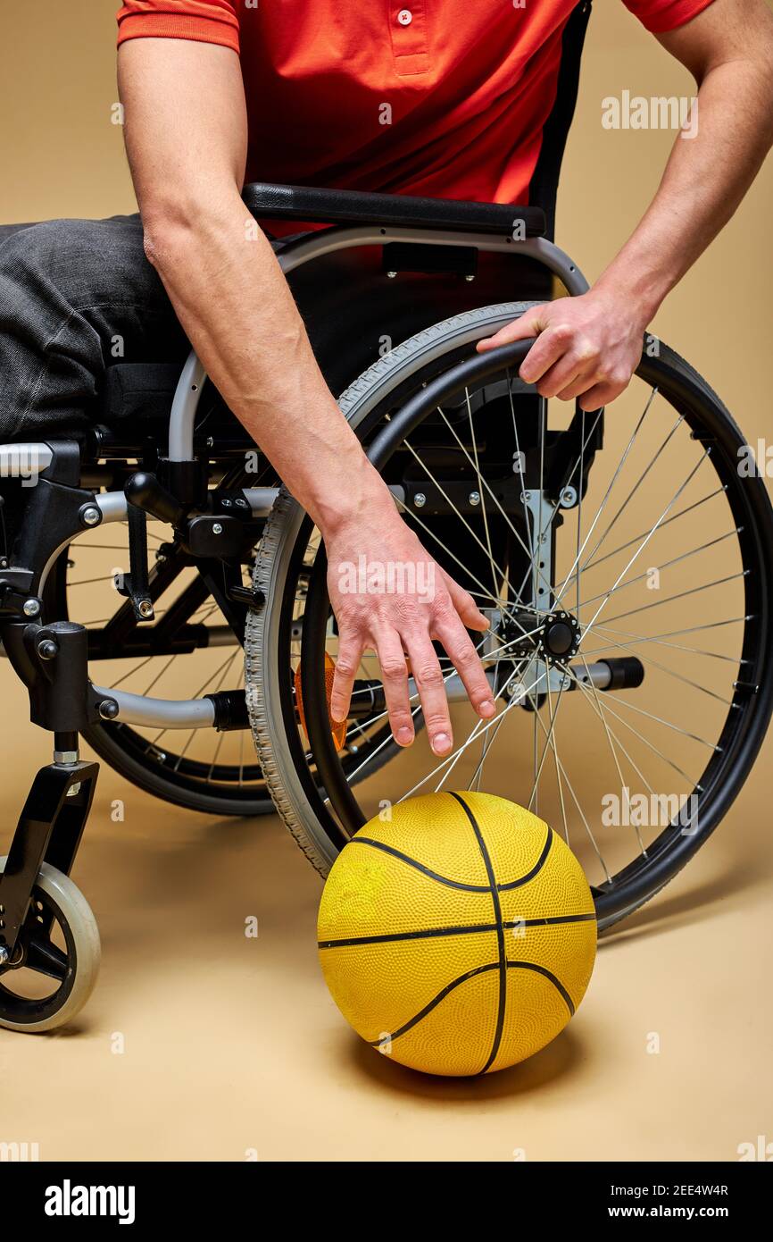disabled sportsman taking basketball ball from the floor, going to play ...