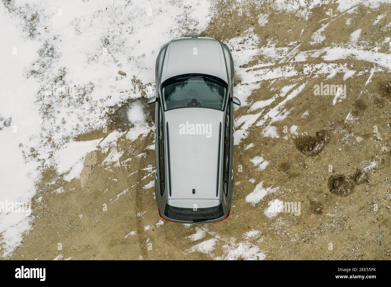 Aerial top view of modern off road SUV car on ground covered with snow ...