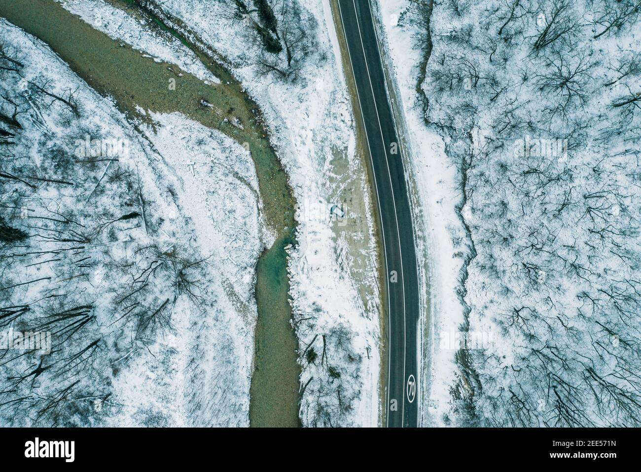 Aerial top view of road and river in mountain gorge in snowy winter day ...