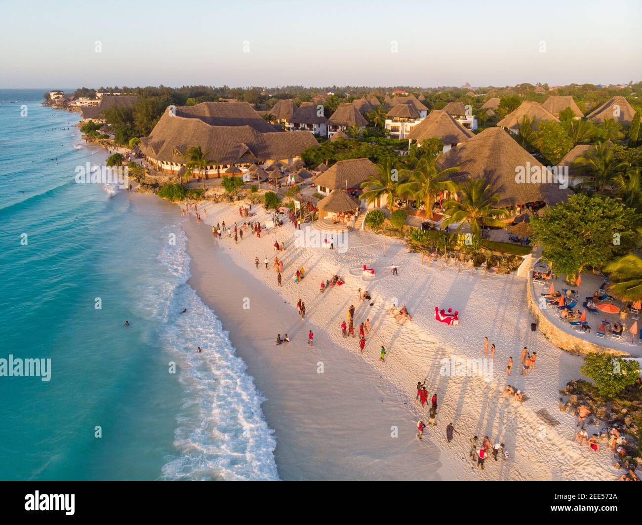 Aerial Shot on Zanzibar a beautiful sunset with people Walking on the ...