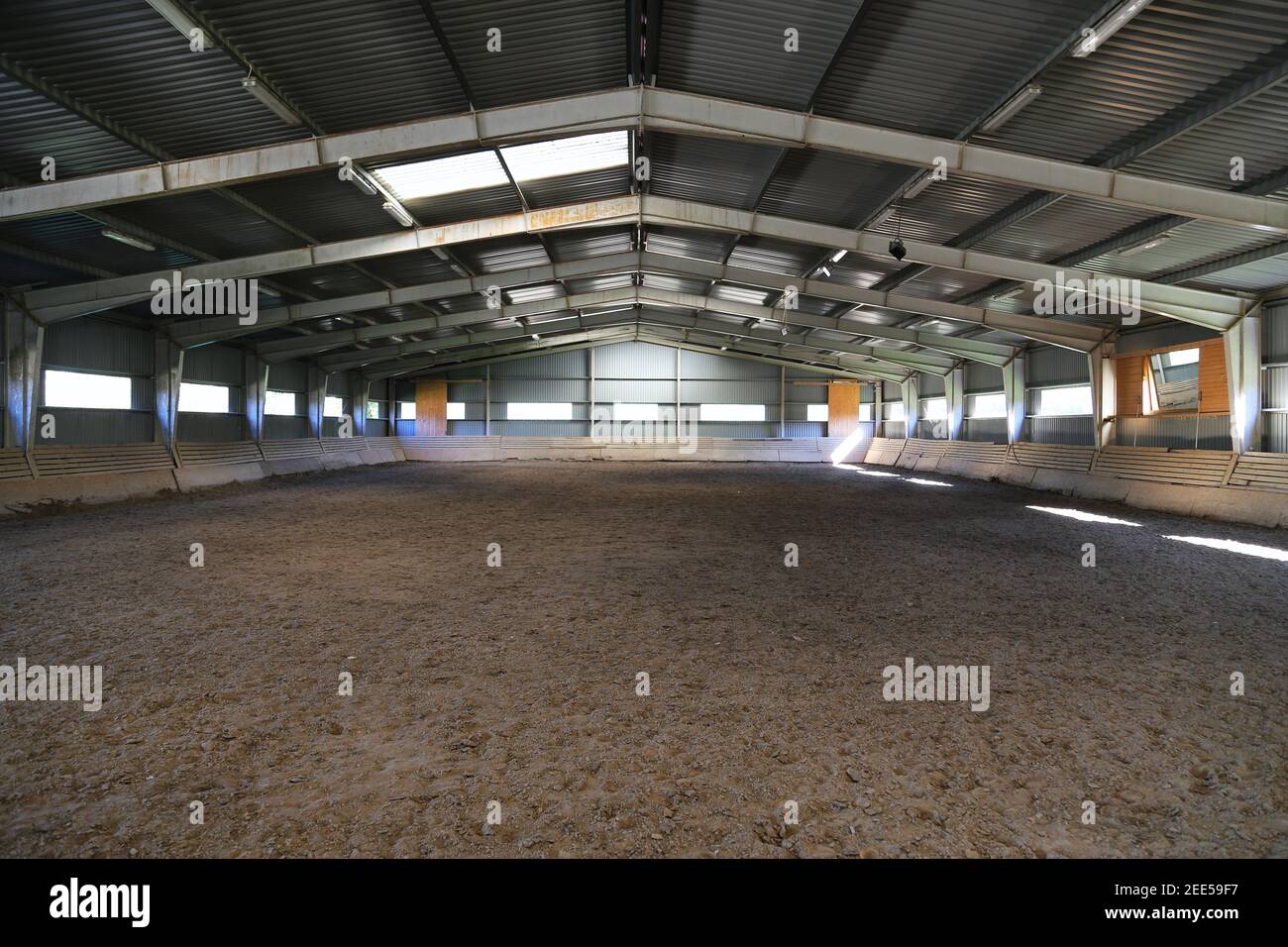 Photo of an empty indoor riding hall for horses and riders. The riding ...
