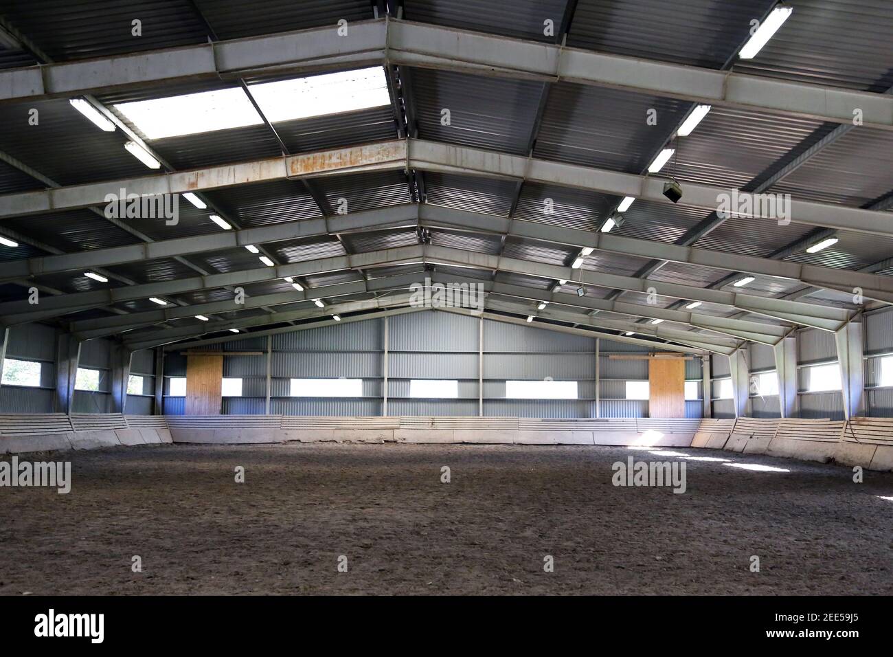 Photo of an empty indoor riding hall for horses and riders. The riding ...