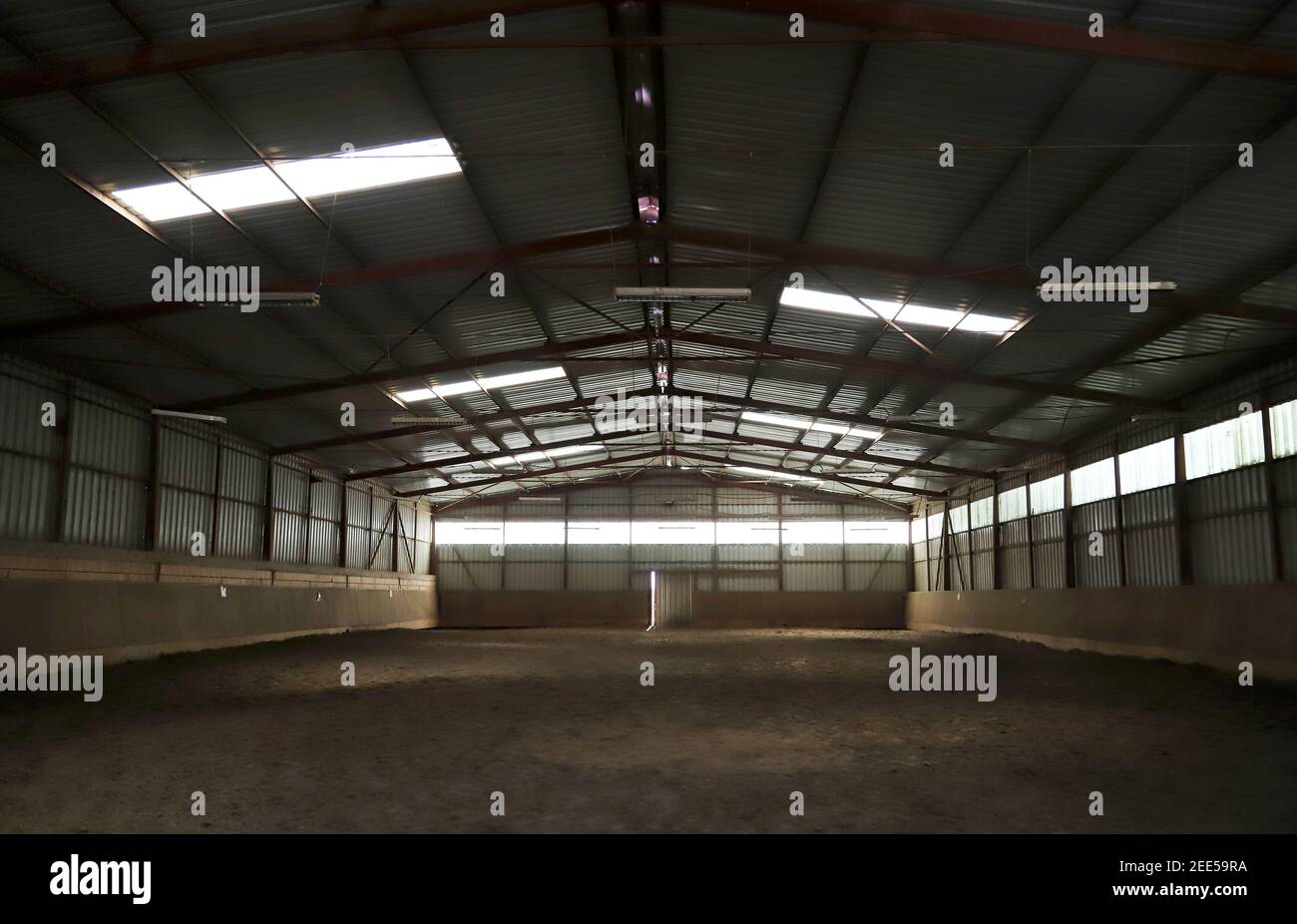 Photo of an empty indoor riding hall for horses and riders. The riding ...