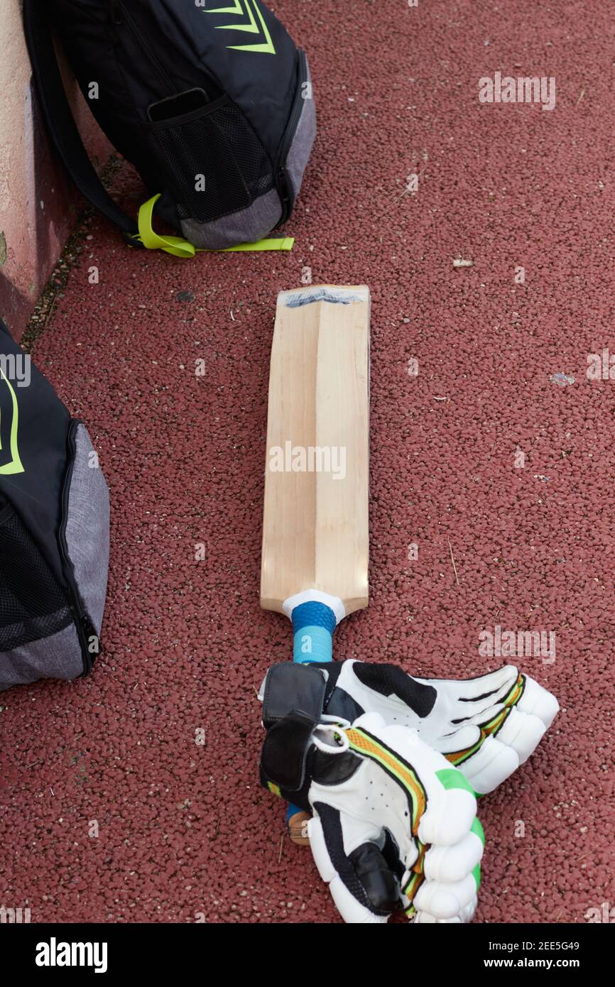 Cricket bat and gloves next to a player's backpack Stock Photo - Alamy