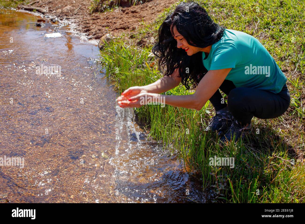 Woman drinking water in a crystal clear stream Stock Photo - Alamy