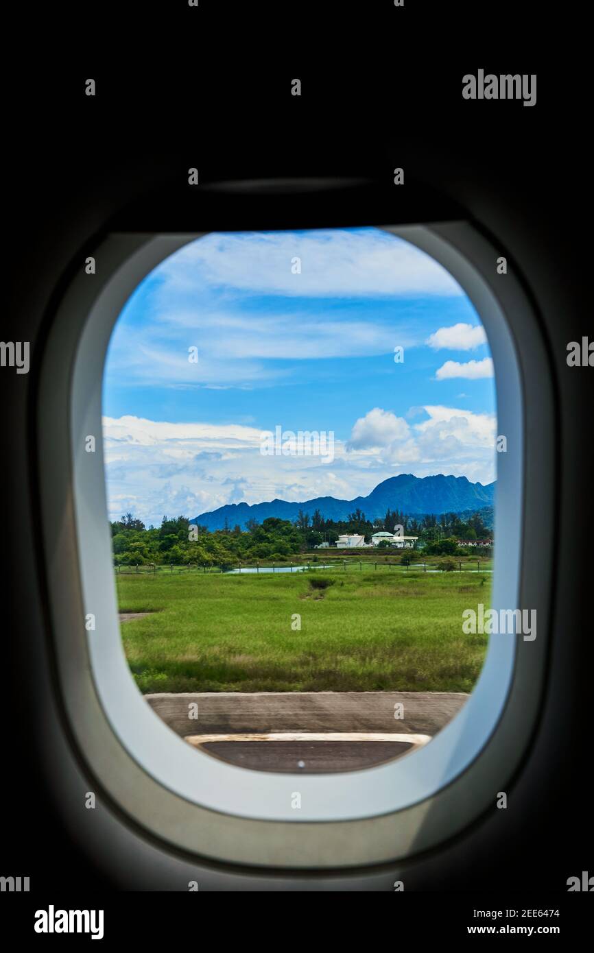 View from the window of an airplane on the runway of a tropical island ...