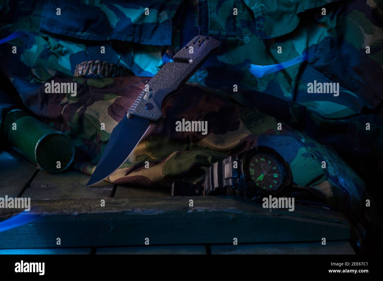 A folding army knife on a camouflage uniform. Military box and knife ...